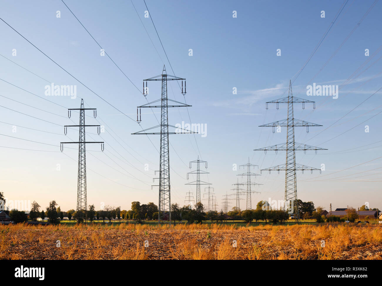 Three parallel power lines crossing flat landscape Stock Photo - Alamy