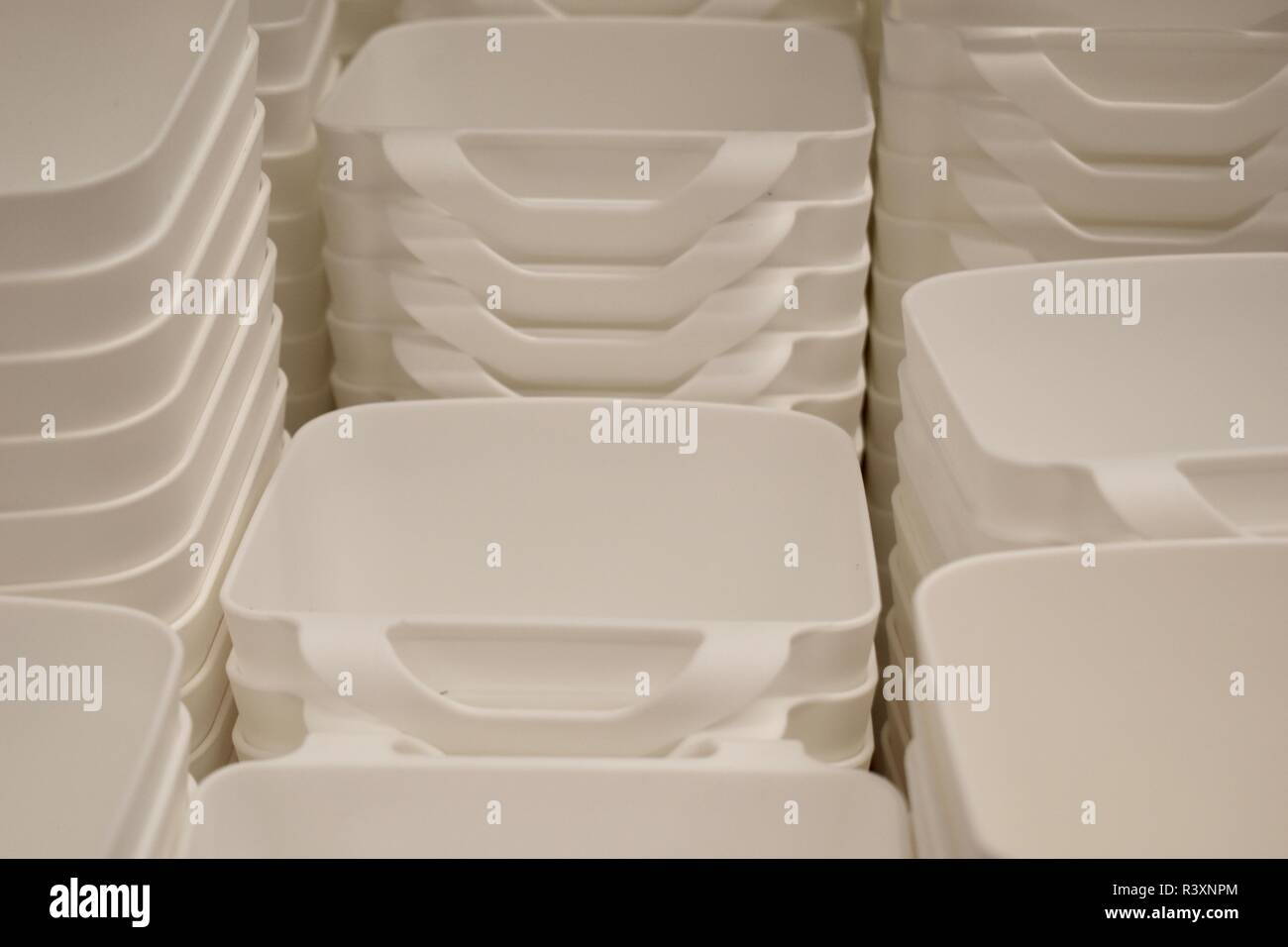Stack of white plastic storage boxes with handles Stock Photo - Alamy