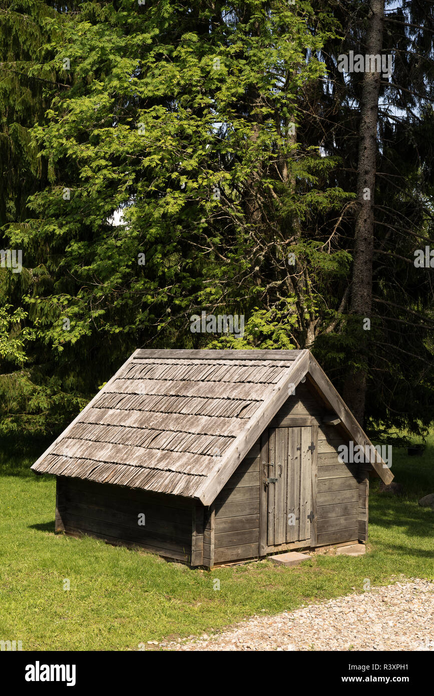 A wooden barn surrounded by mixed forest. Old cottage on green ...