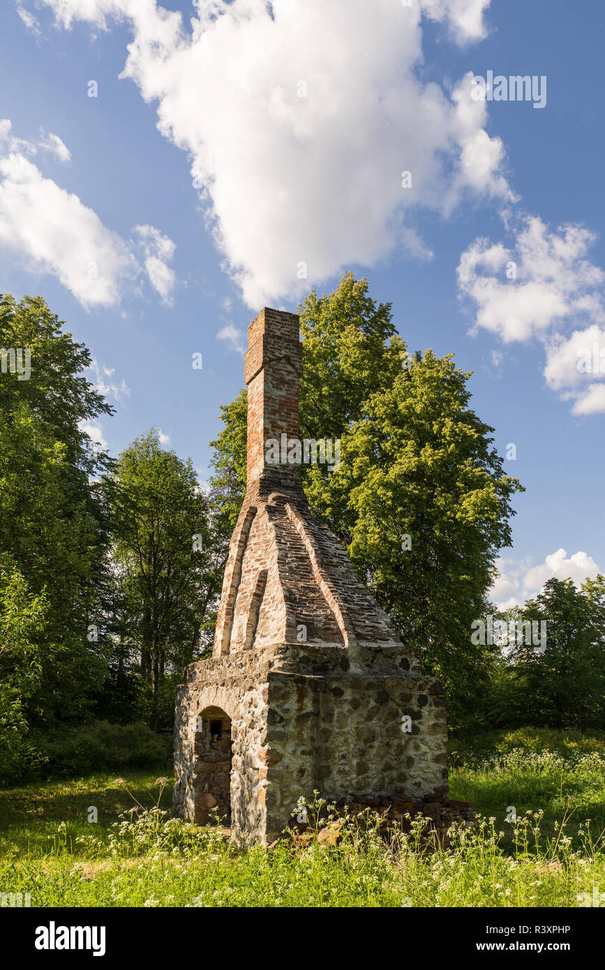 Abandoned ruin of oven chimney. Broken furnace. Green meadow ...