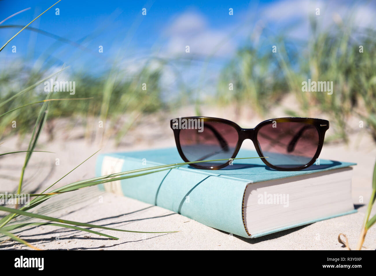 sunglasses on book Stock Photo - Alamy