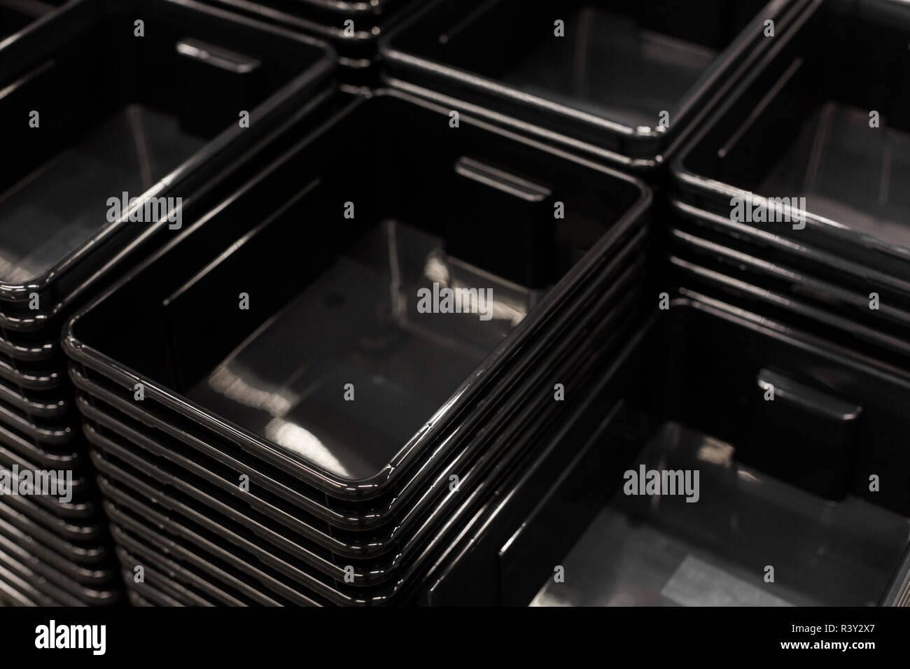 black plastic containers stack in a store Stock Photo - Alamy