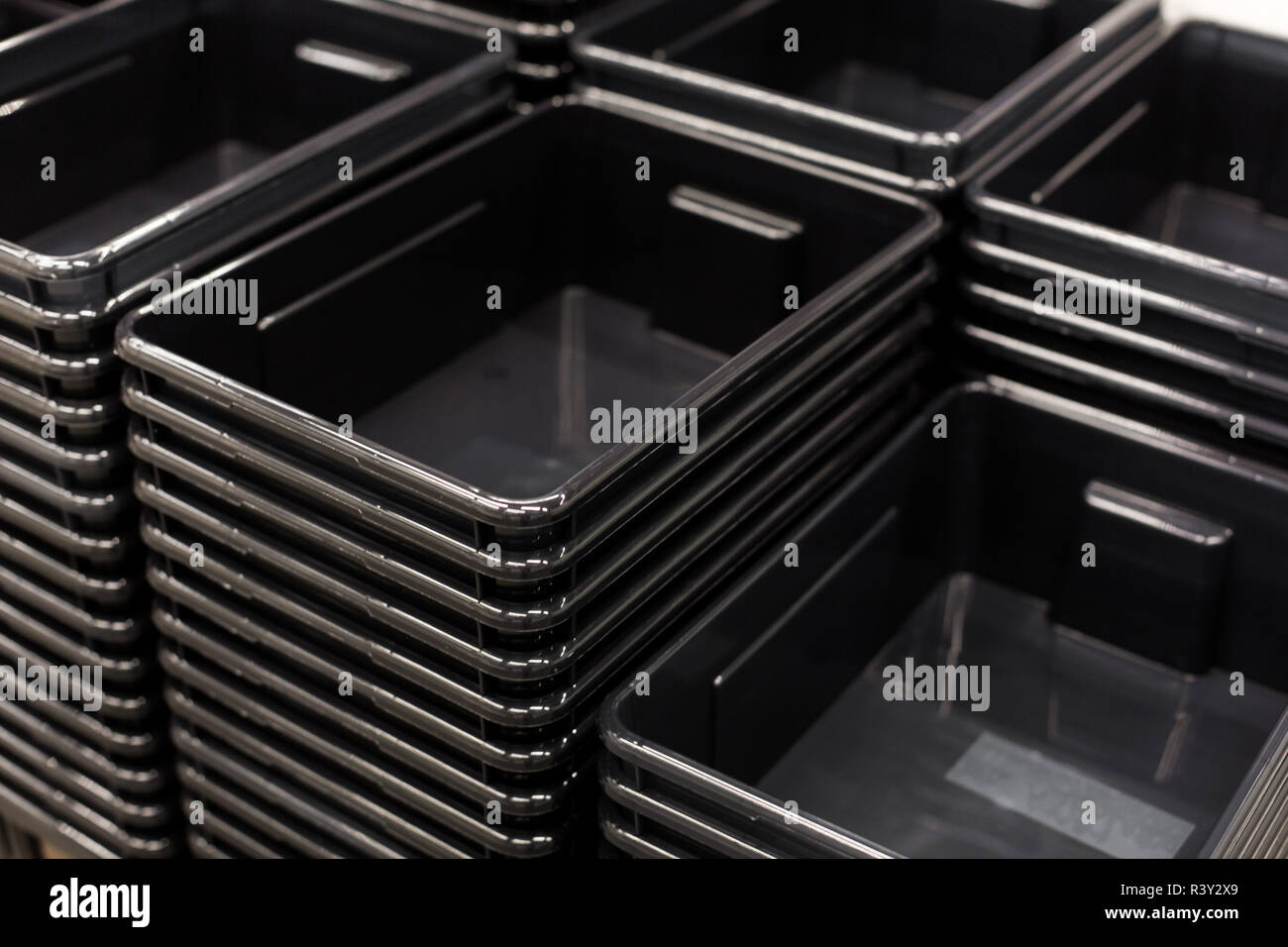 black plastic containers stack in a store Stock Photo - Alamy