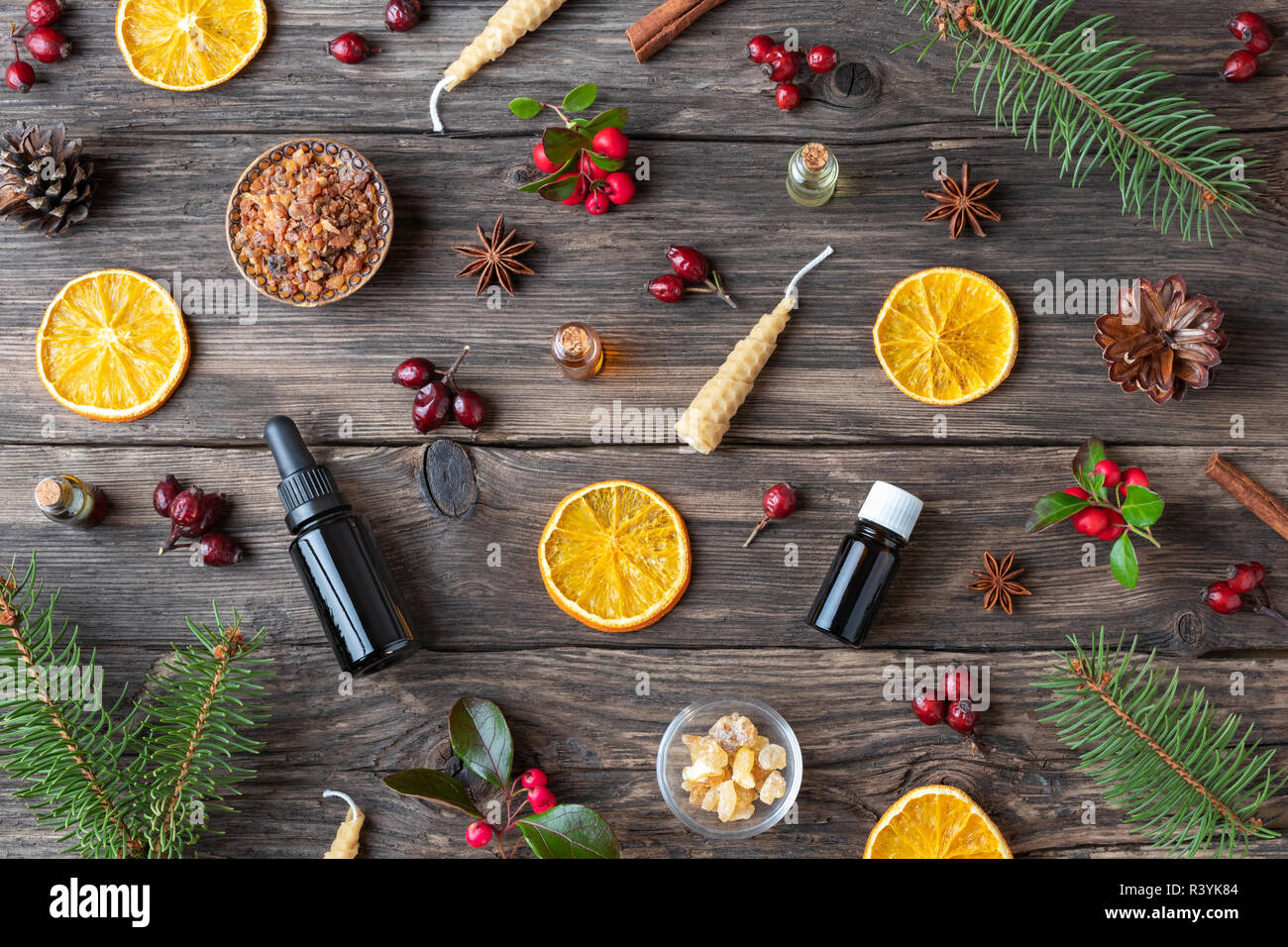 Bottles of essential oil on a wooden Christmas background with myrrh ...