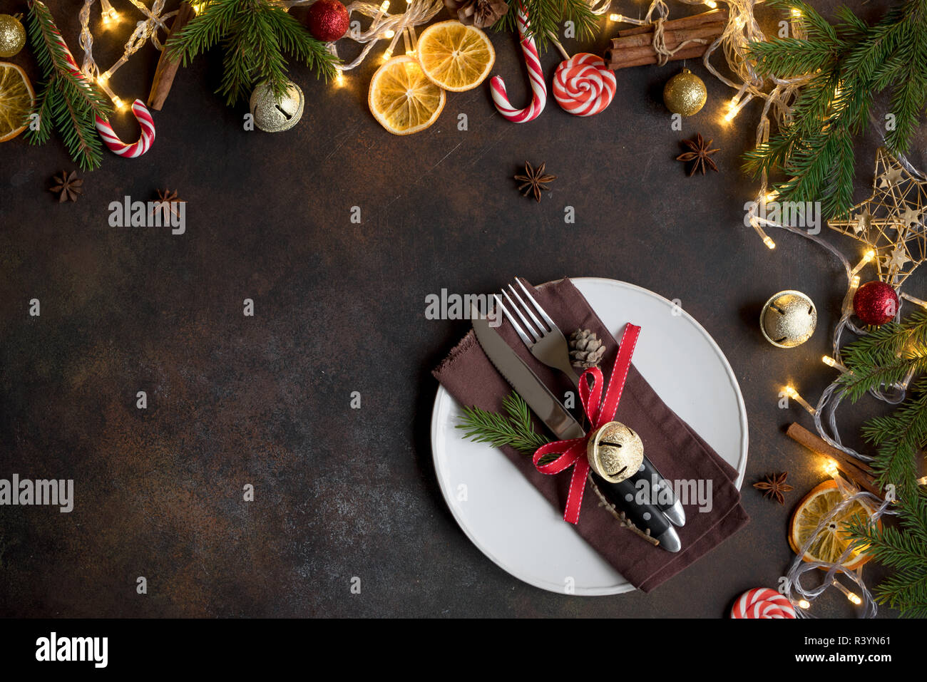 Christmas table setting and border with lights, spices, balls, fir ...