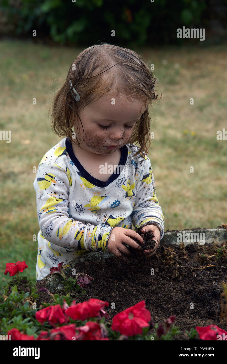 Toddler playing in the dirt in garden Stock Photo - Alamy
