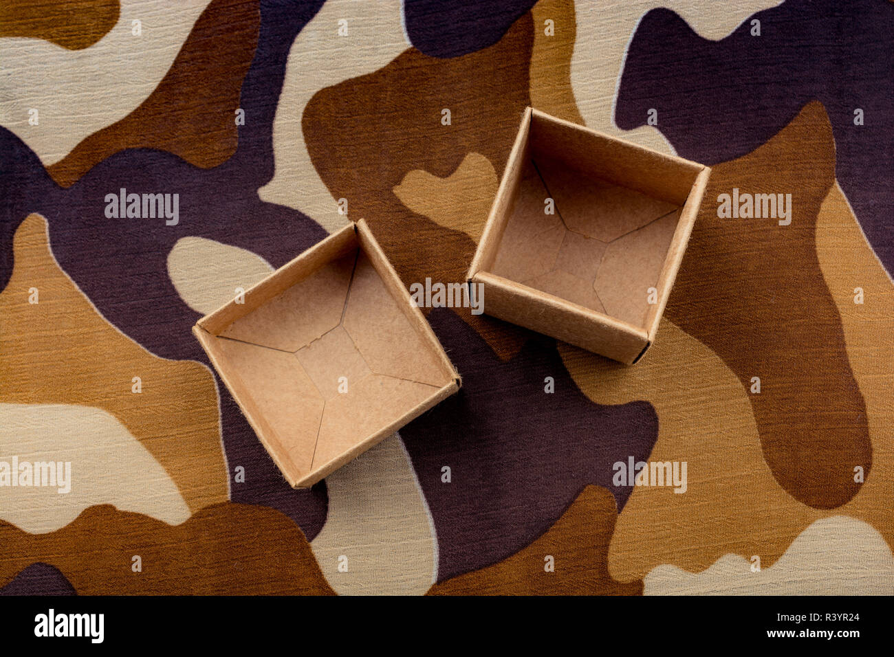 Two open cardboard boxes on a camouflage background Stock Photo - Alamy