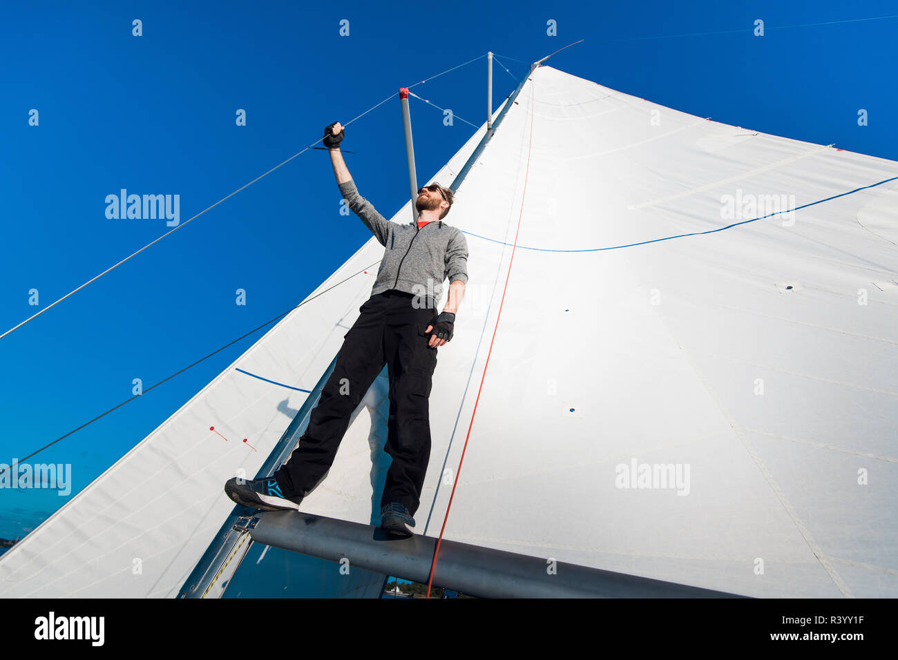 Young seaman on a sailboat standing on a sail boom. Captain of the ...