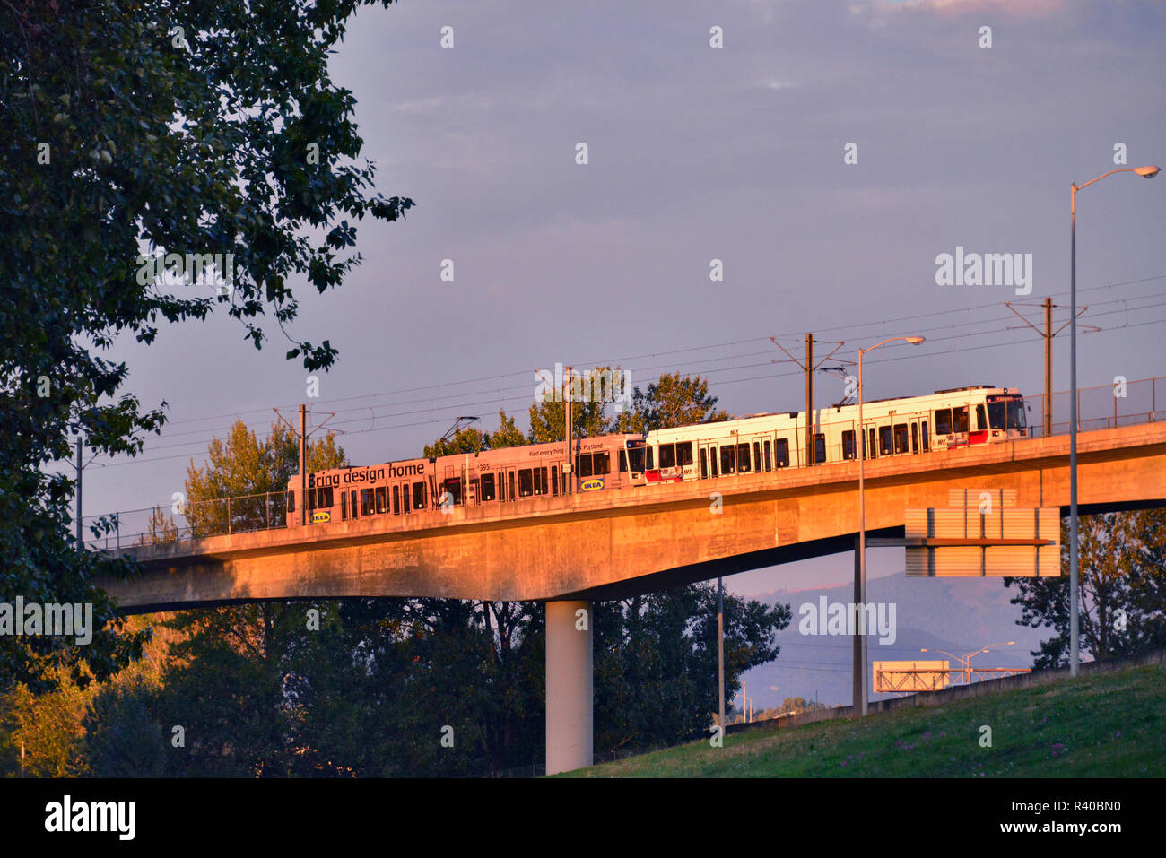 USA, Oregon, Portland. MAX light rail on overpass at sunset. Credit as ...