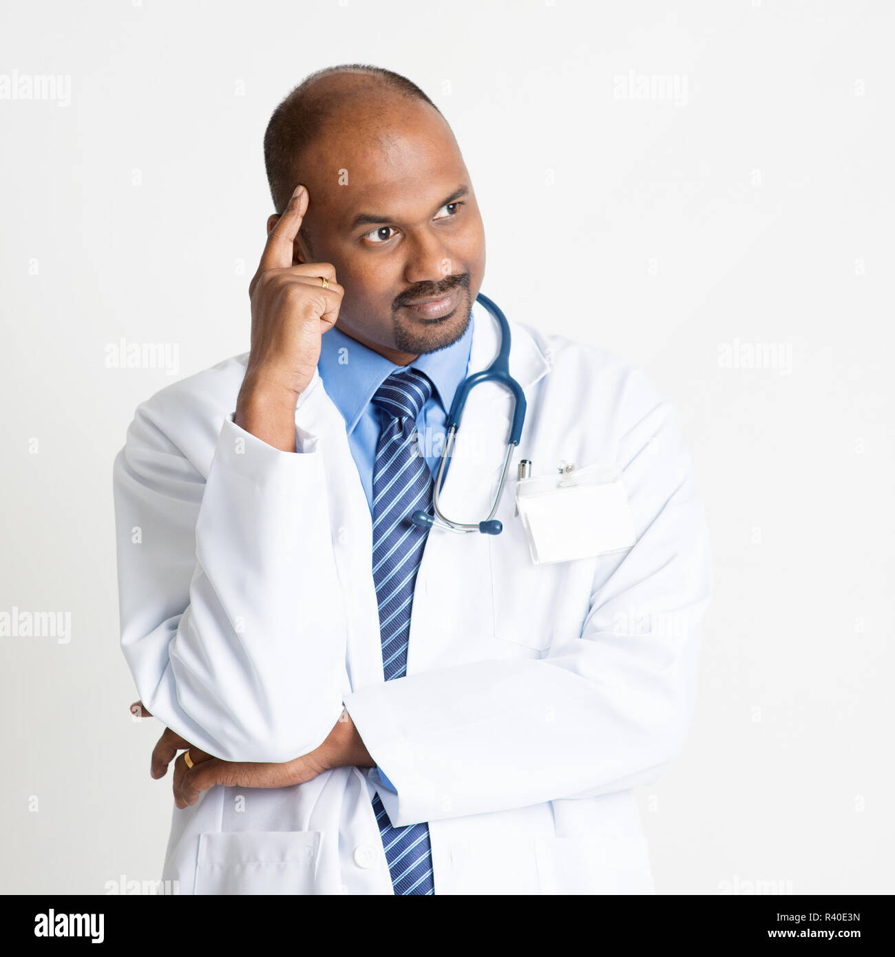 Mature Indian doctor thinking Stock Photo - Alamy