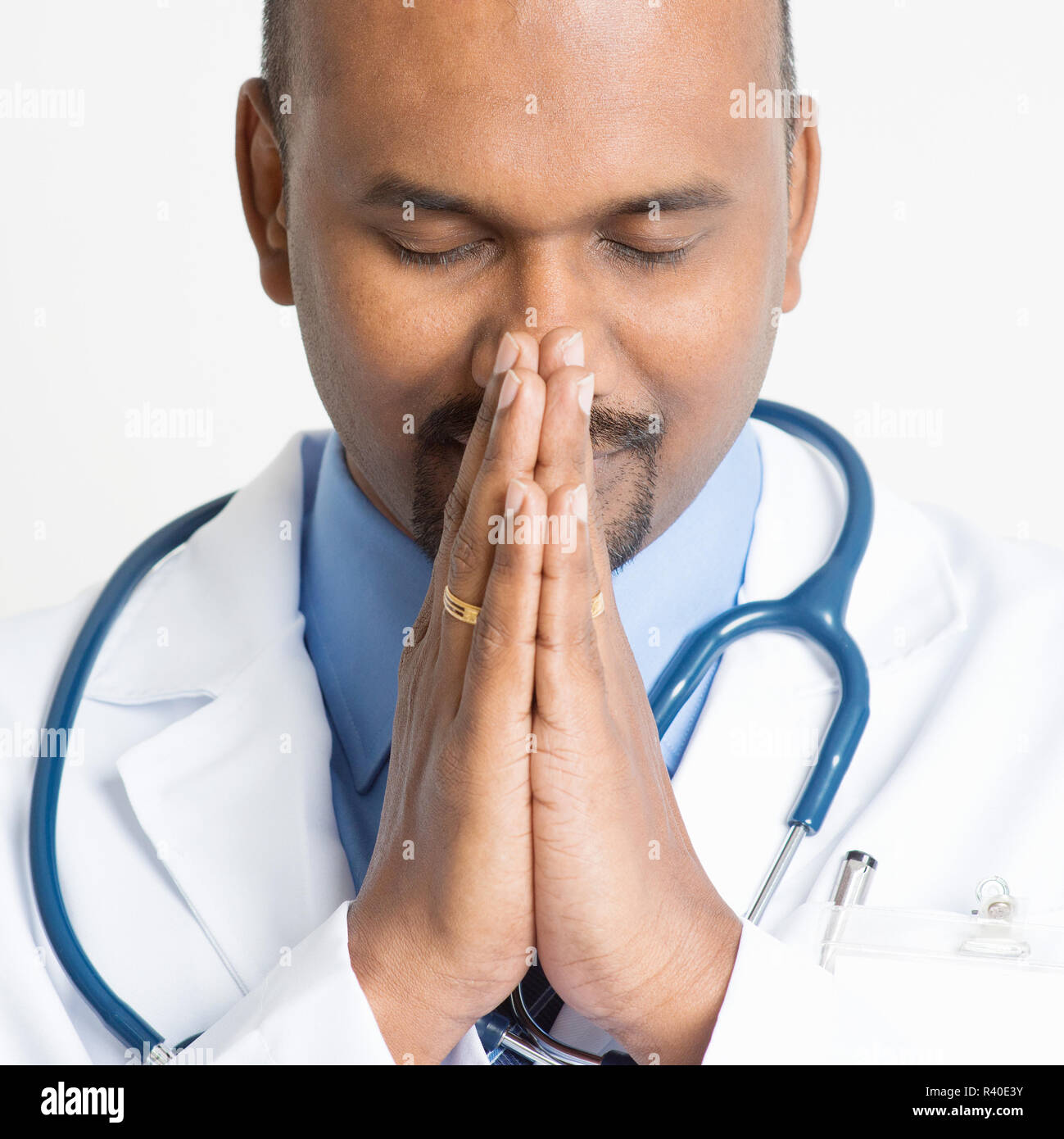 Close up Mature Indian doctor praying Stock Photo - Alamy