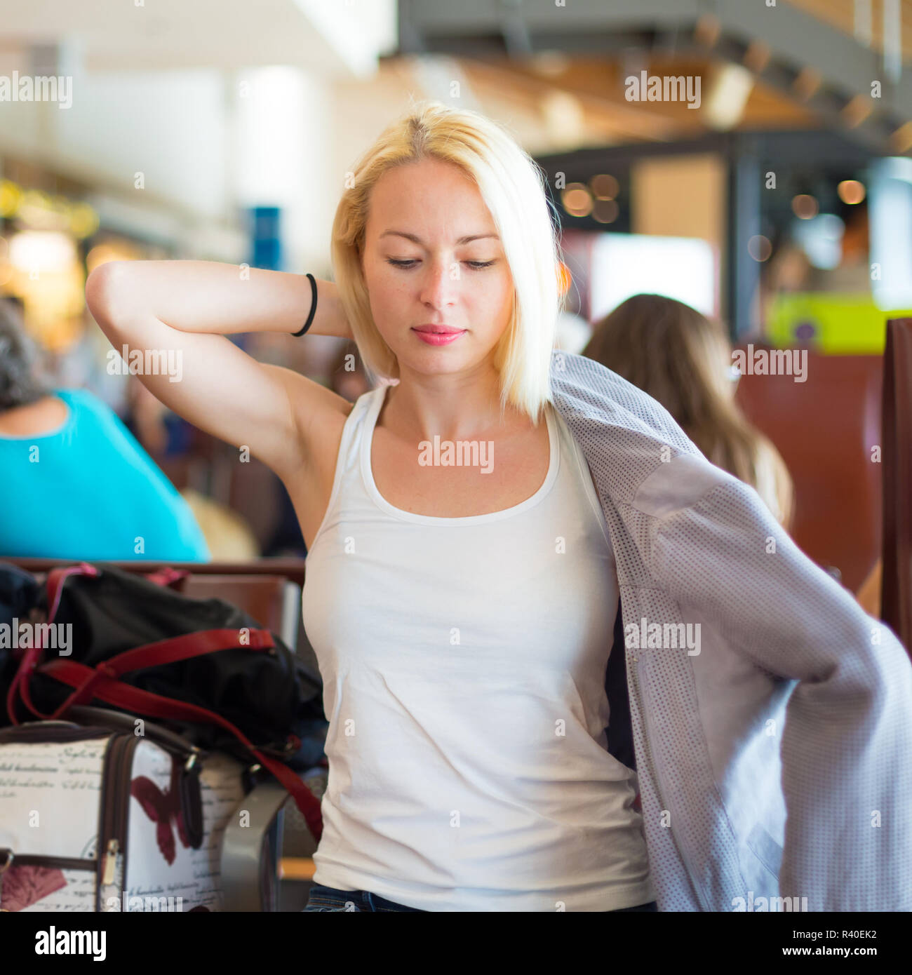Female traveler putting on her jacket Stock Photo - Alamy