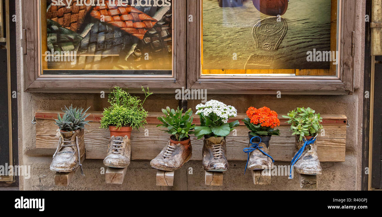 Old shoes as planters - Shoe store advertising in historic town of ...