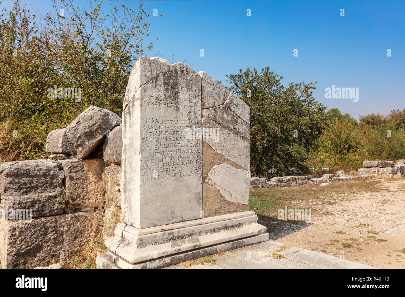 Detail of marble column with ancient Greek scripture and plinth at ...