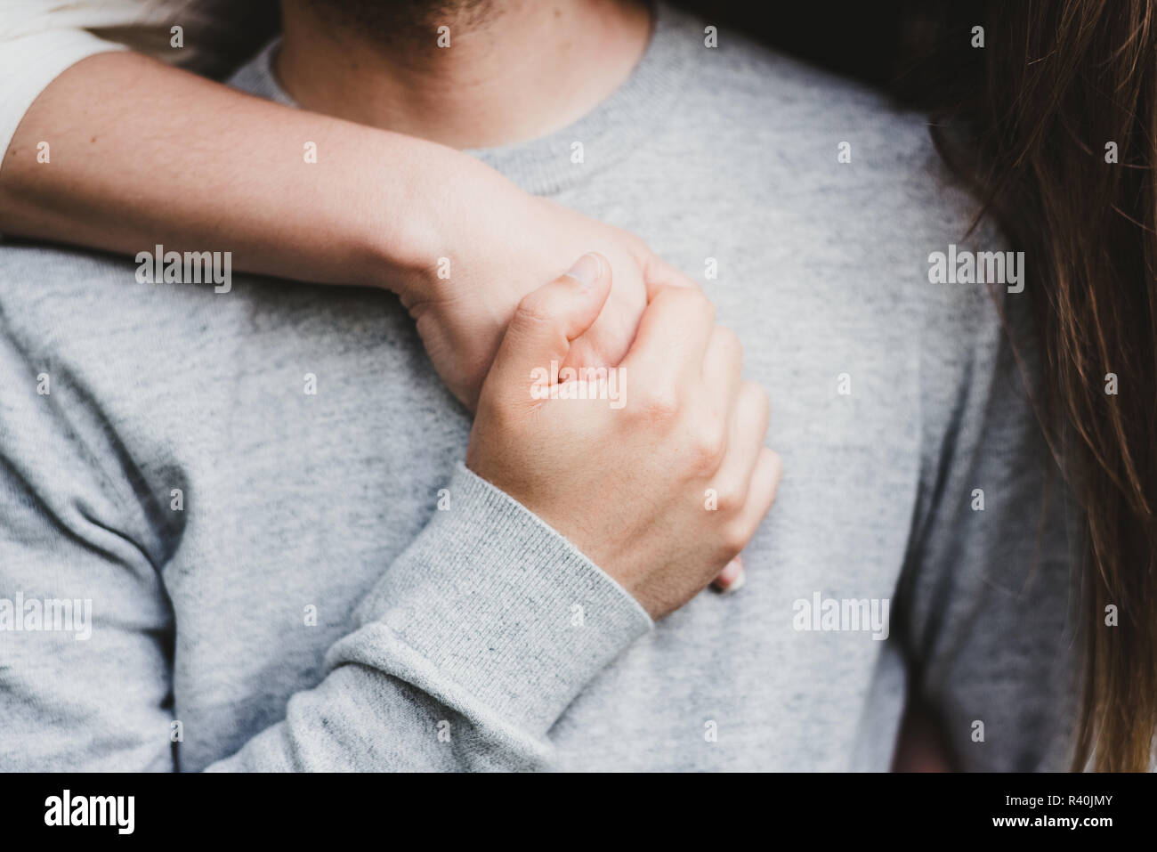 Couple in love hugging each other with their hands Stock Photo - Alamy