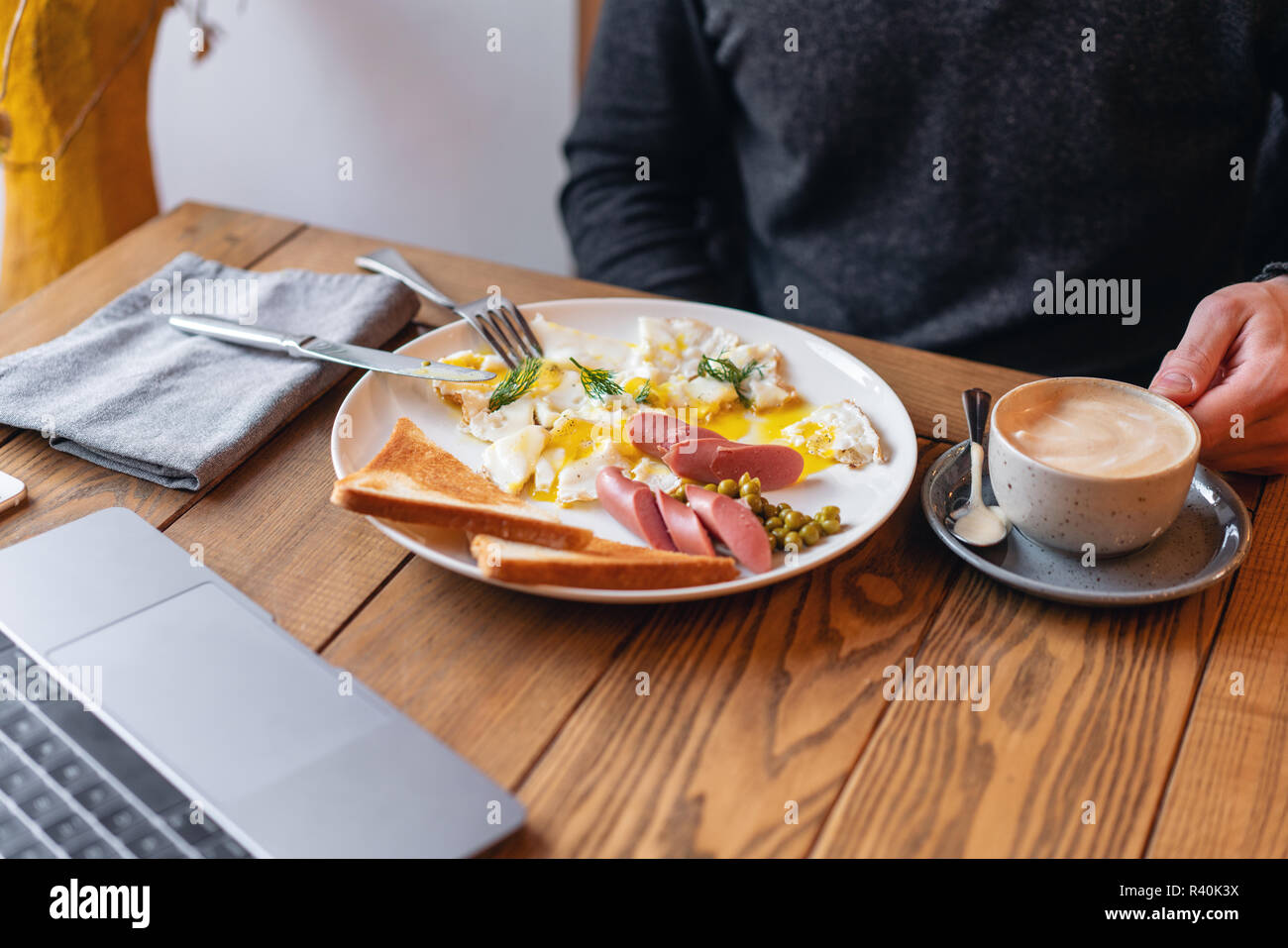 The concept of eating at work. Laptop and Breakfast on the table ...