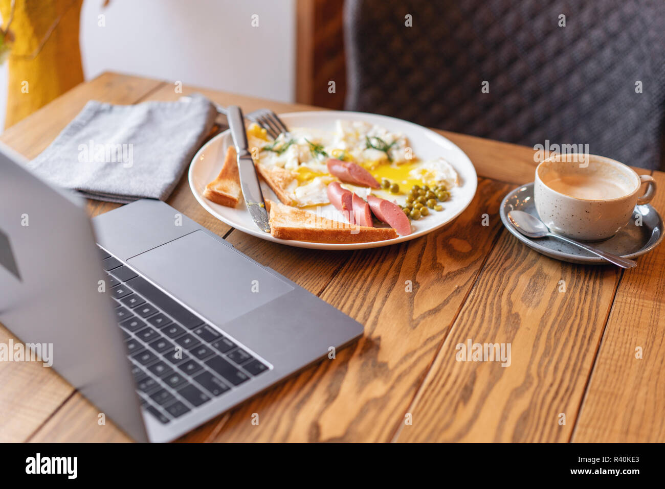 The concept of eating at work. Laptop and Breakfast on the table ...