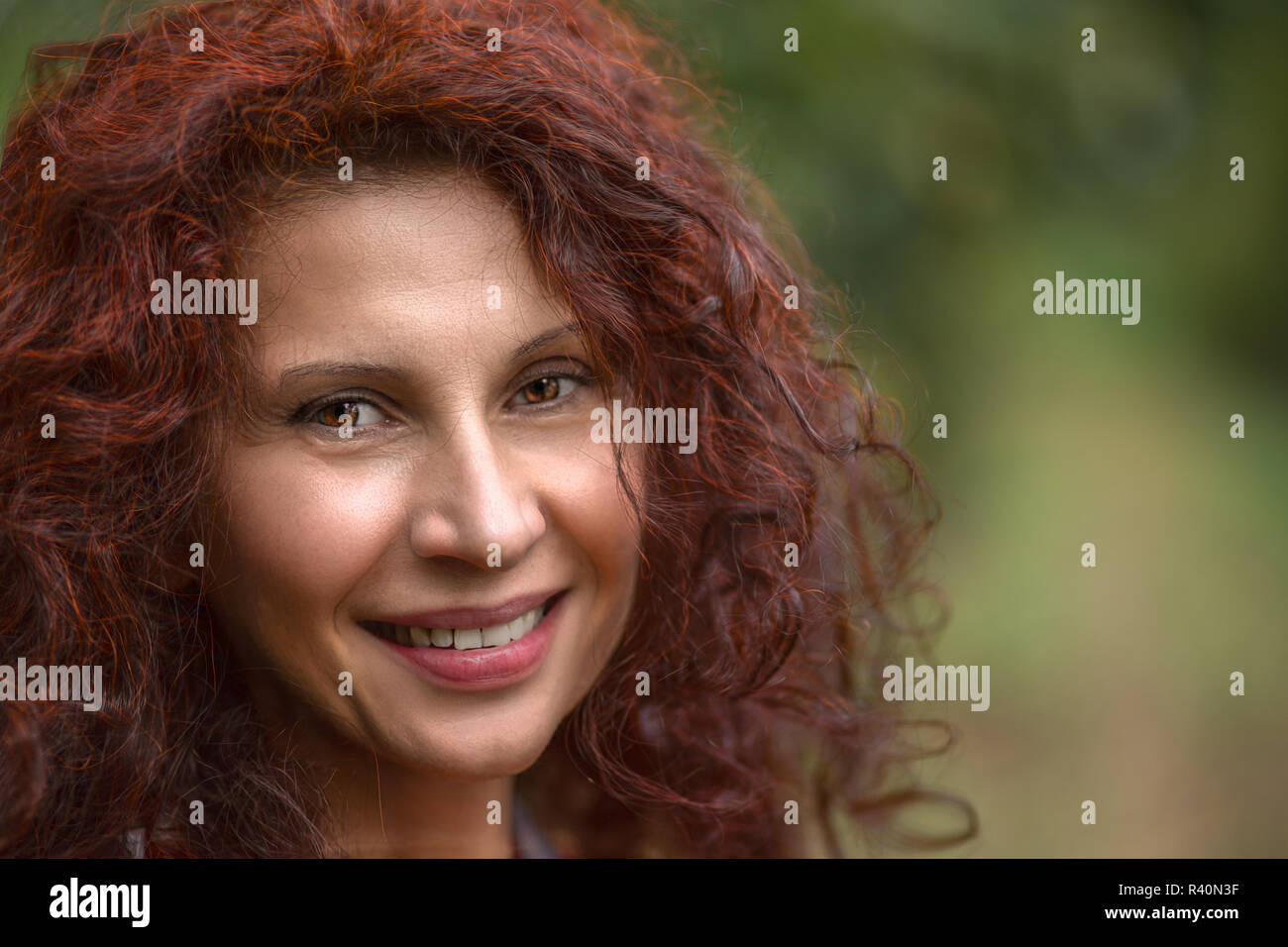 portrait of girl with long red hair and Middle Eastern features smiling ...