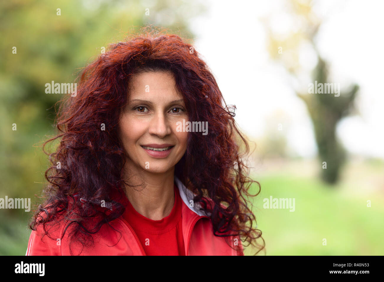 Girl in red gym suit smiling in garden. long red hair and Middle ...