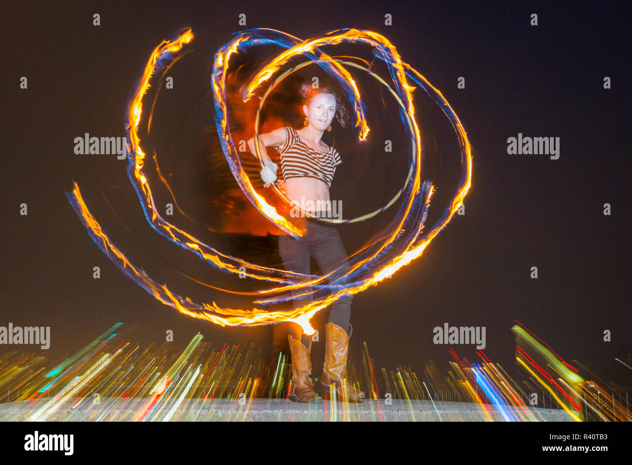 USA, Washington State, Seattle. Young woman juggling with fire in an ...