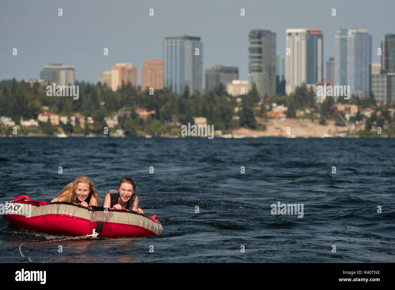 USA, Washington State, Bellevue. Two teenage girls tubing, or ...