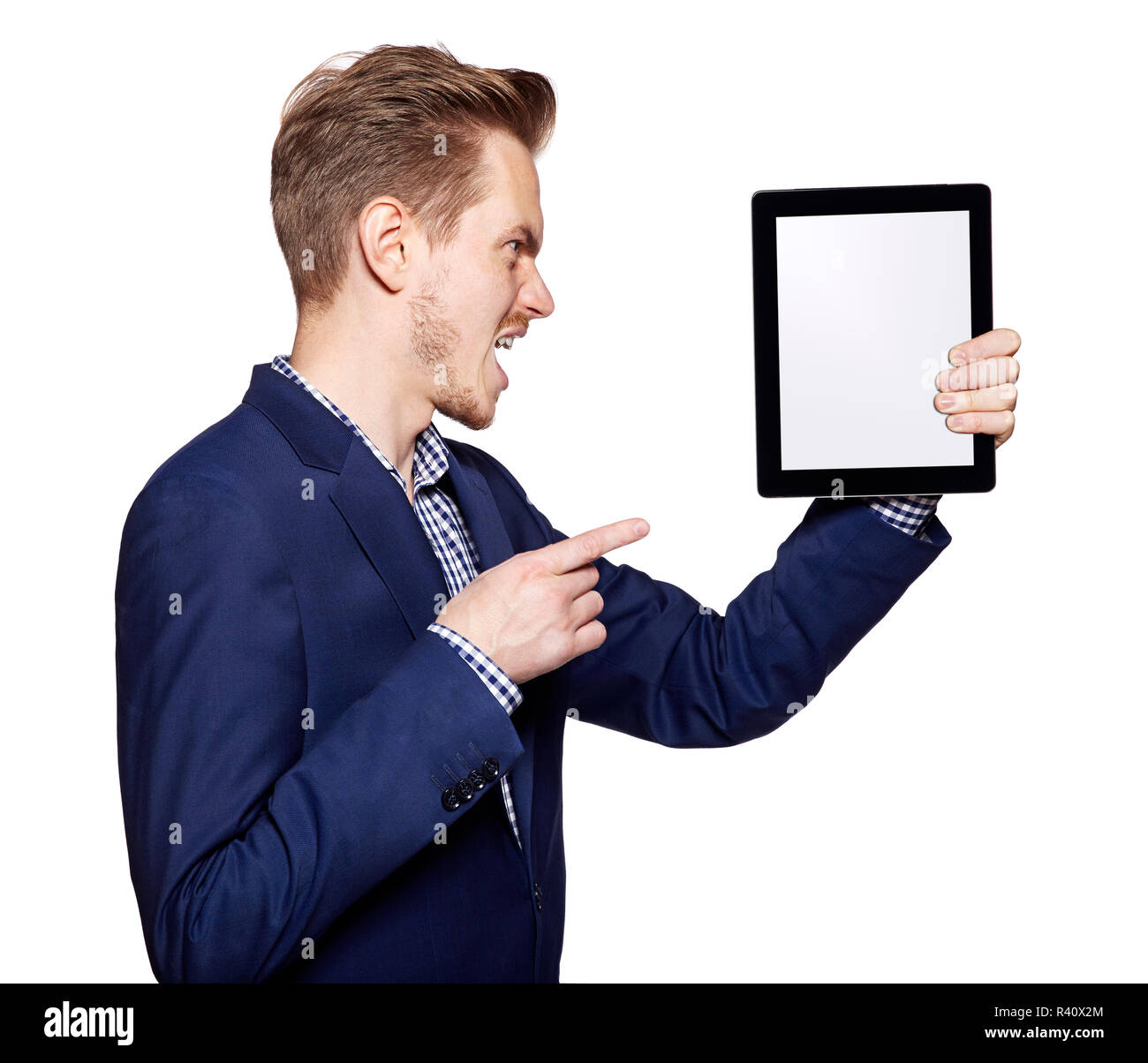 Angry young man pointing at tablet PC Stock Photo - Alamy
