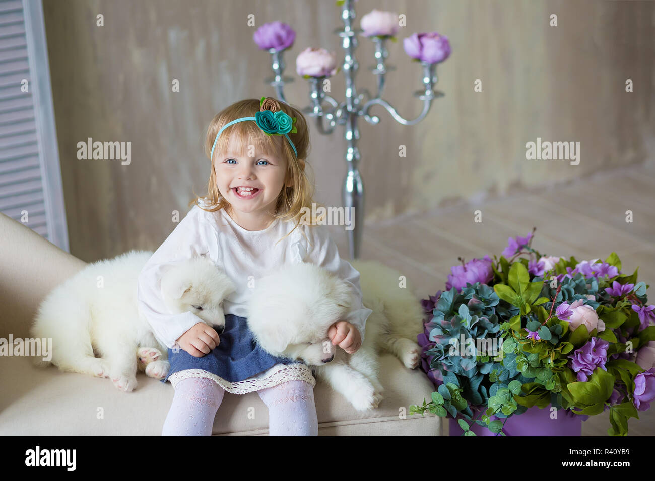Portrait of blond baby girl play with husky puppy.Model girl with blond ...