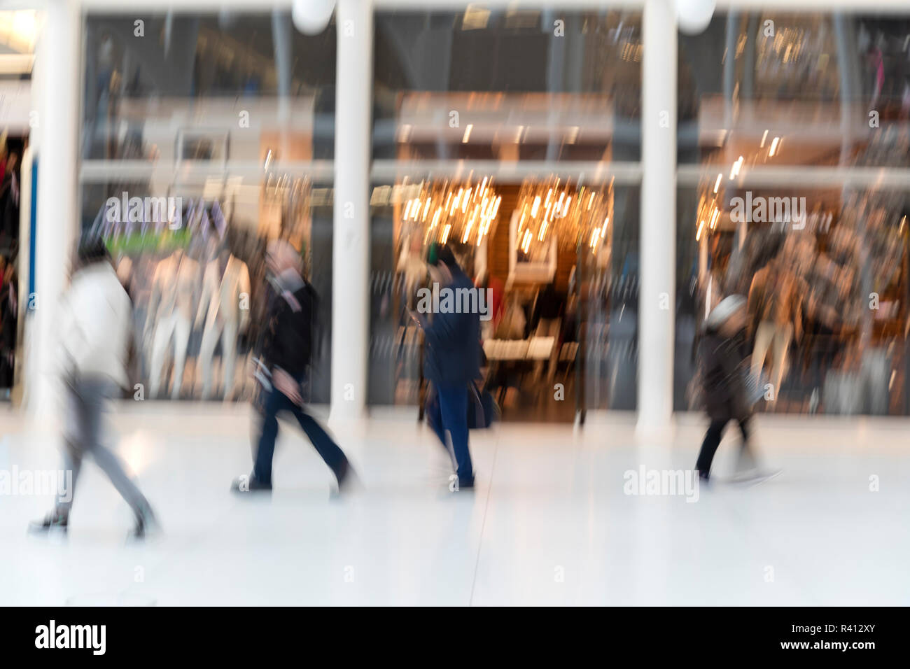 A shopper walking in front of shop window at dusk Stock Photo - Alamy