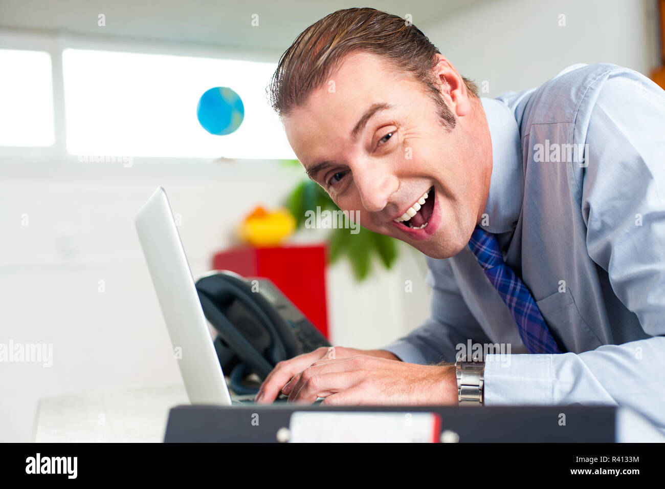 Excited businessman working on laptop Stock Photo - Alamy