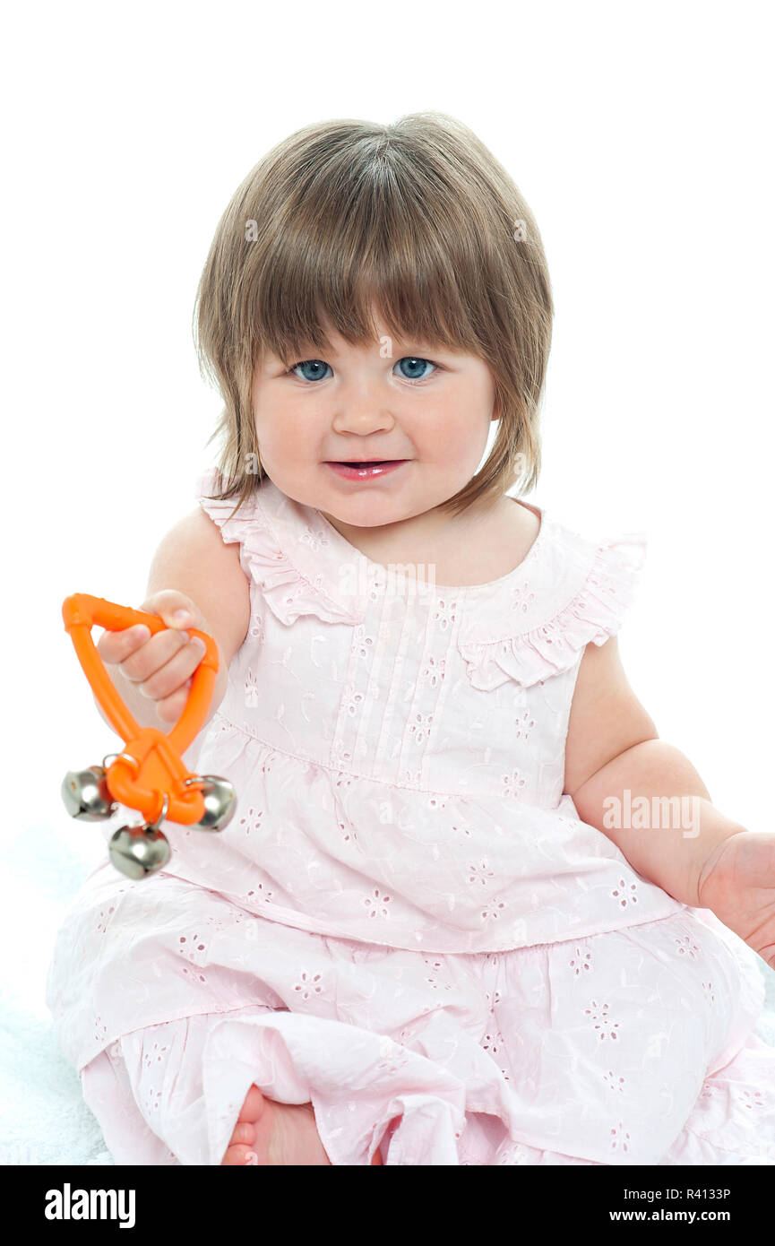 Sweet little girl with a rattle Stock Photo - Alamy