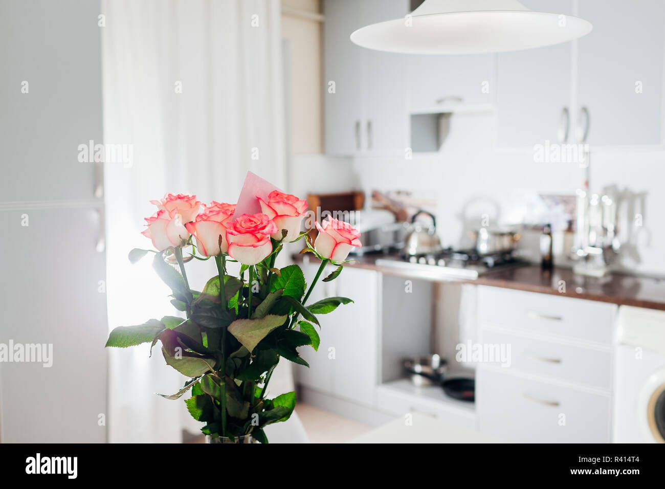 Bouquet of roses with card left on kitchen. Modern kitchen design ...