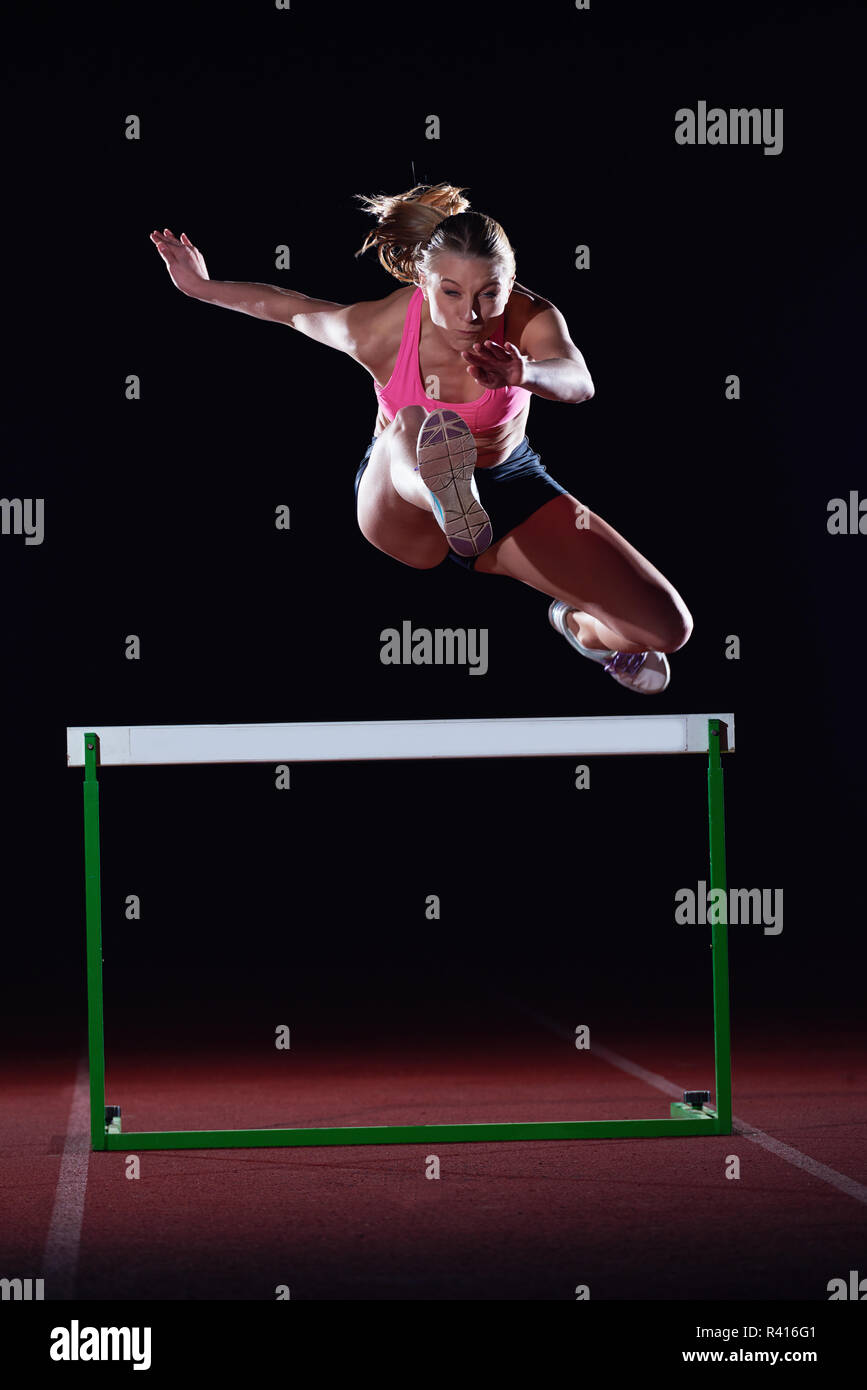 woman athlete jumping over a hurdles Stock Photo - Alamy