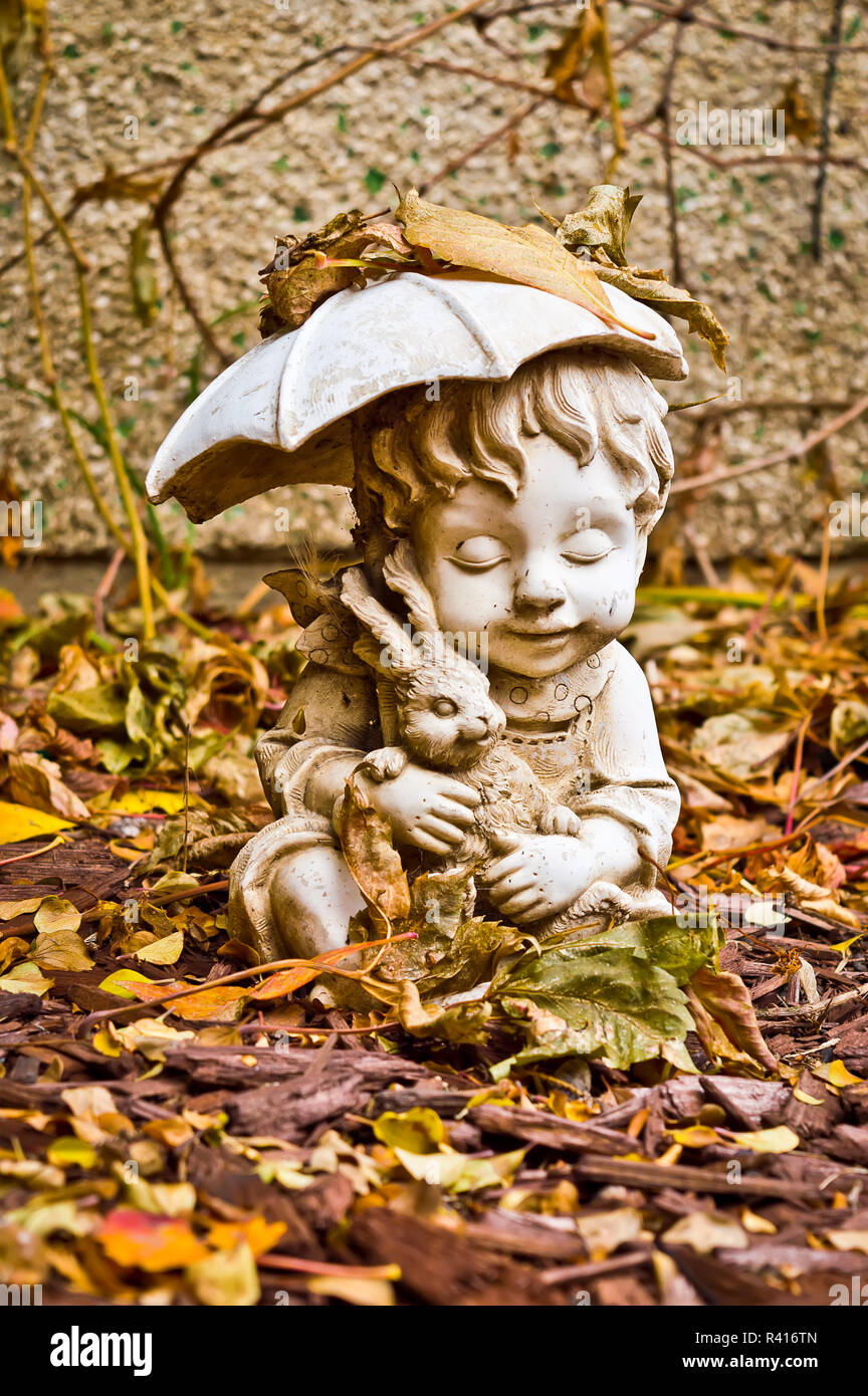 Boy with Umbrella Statue Topped by Leaves Stock Photo - Alamy