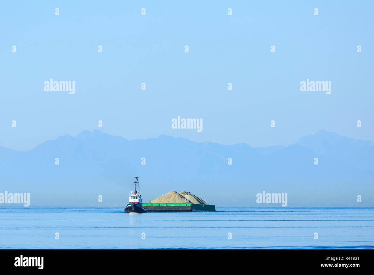 A tugboat pulling a barge of sand in Puget Sound near the San Juan ...