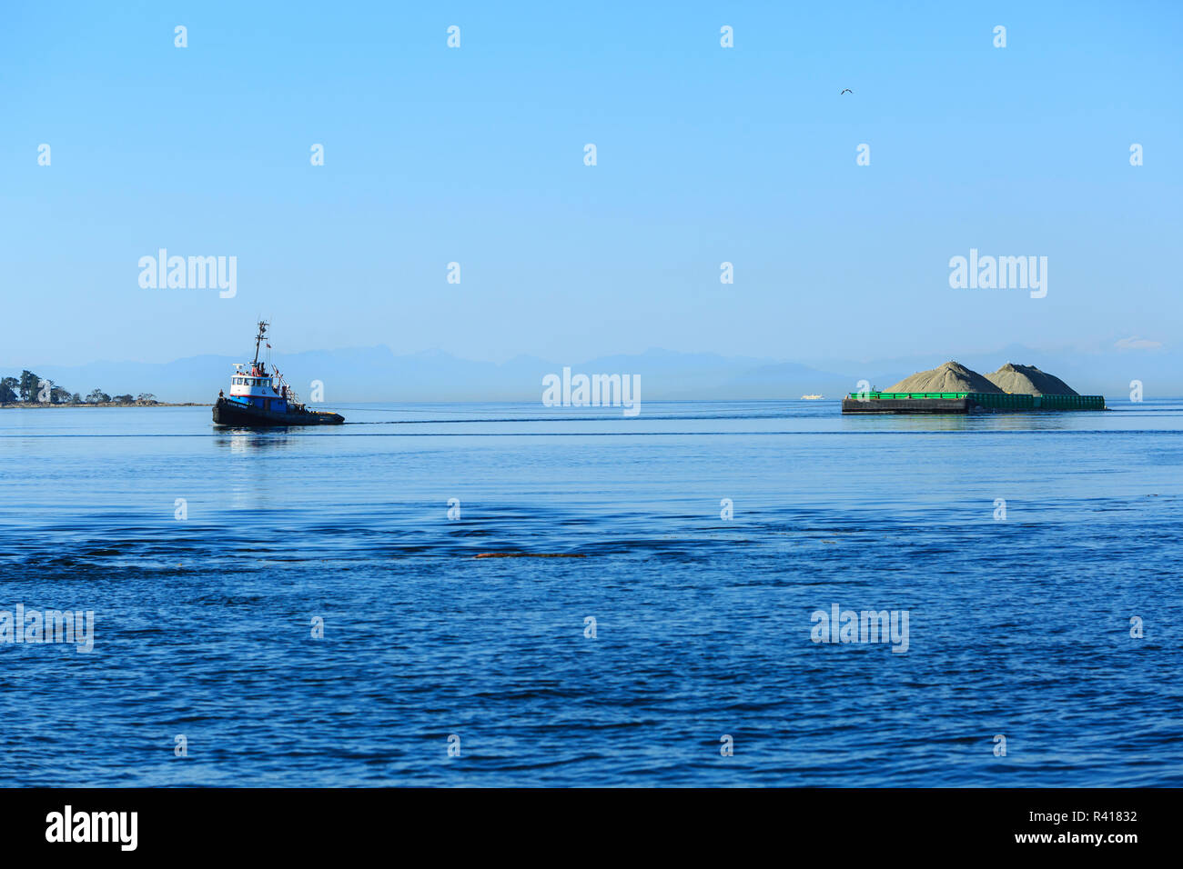 A tugboat pulling a barge of sand in Puget Sound near the San Juan ...