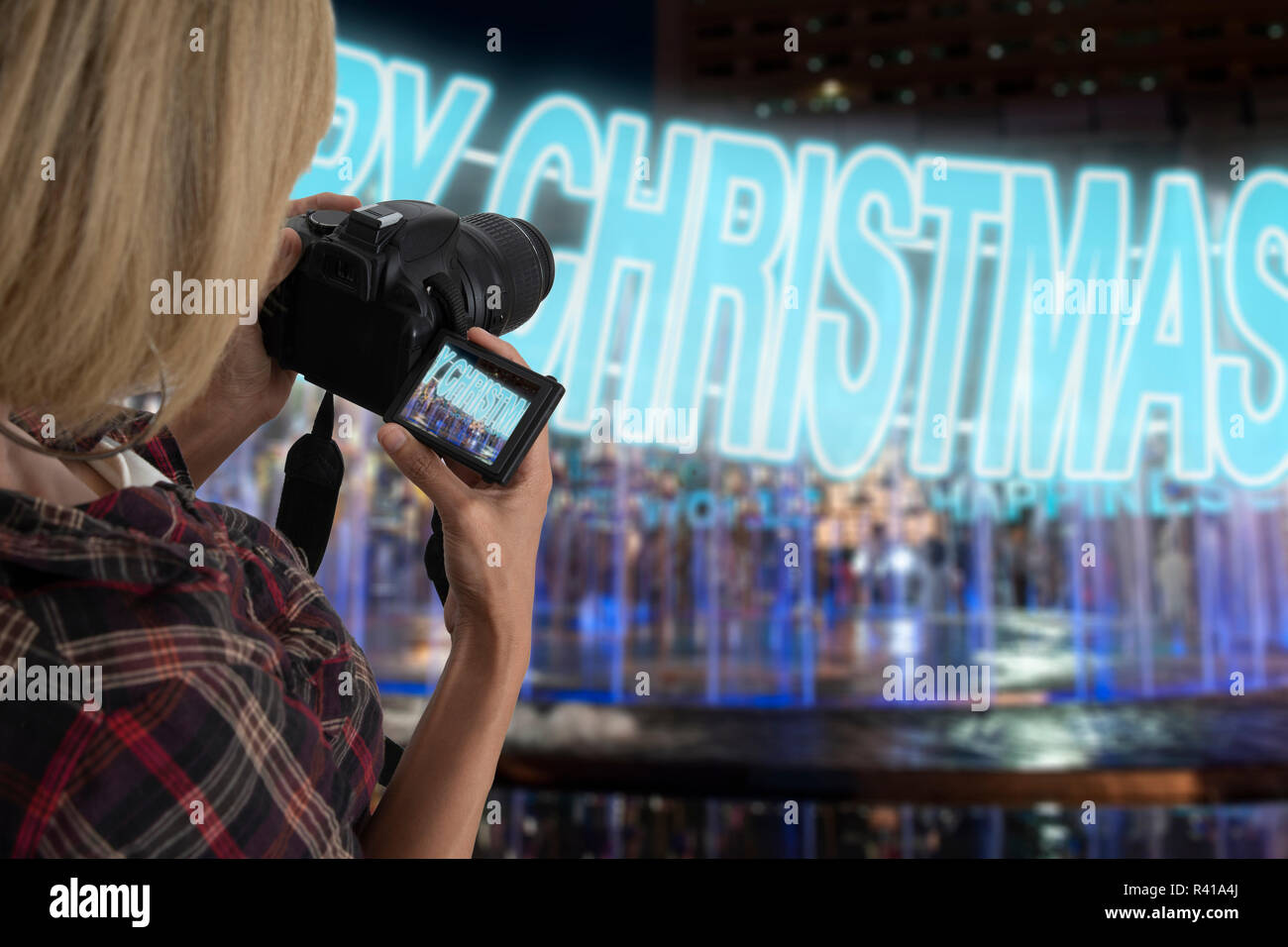Girl taking photo of beautiful neon backlight in christmas celebration ...