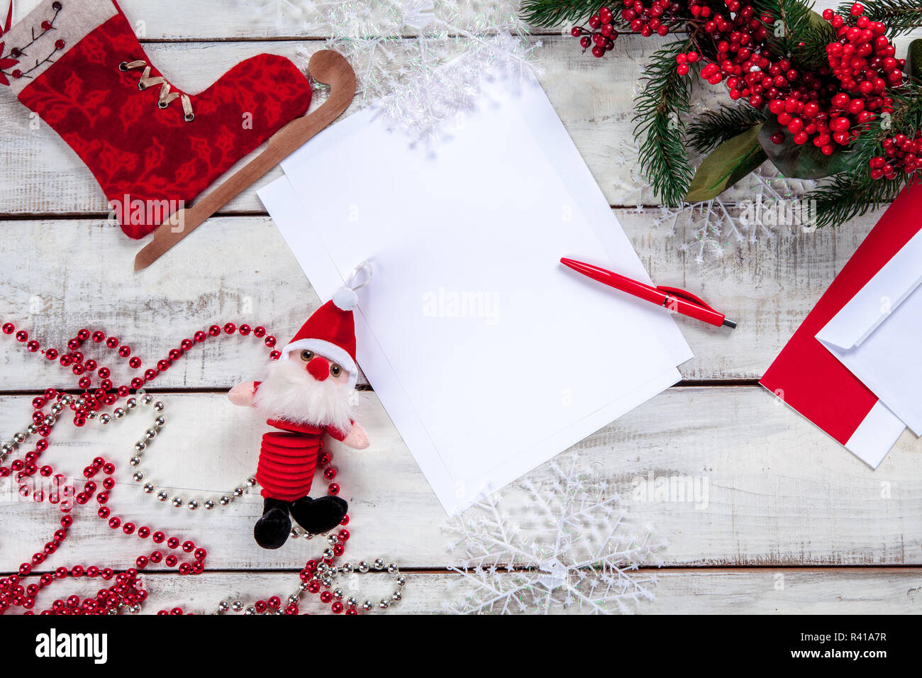 The blank sheet of paper on the wooden table with a pen and Christmas ...