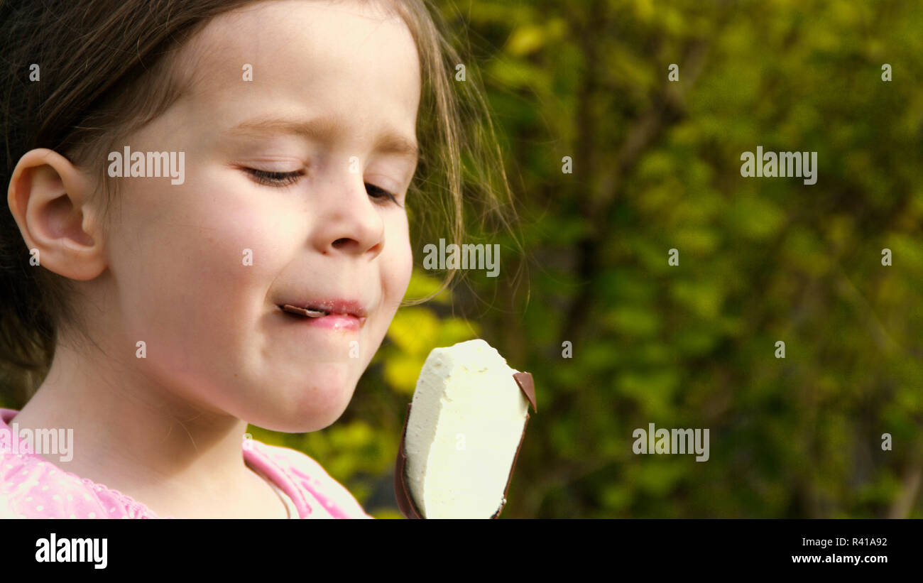 a little girl eats in the green eskimo limon - part 4 Stock Photo - Alamy
