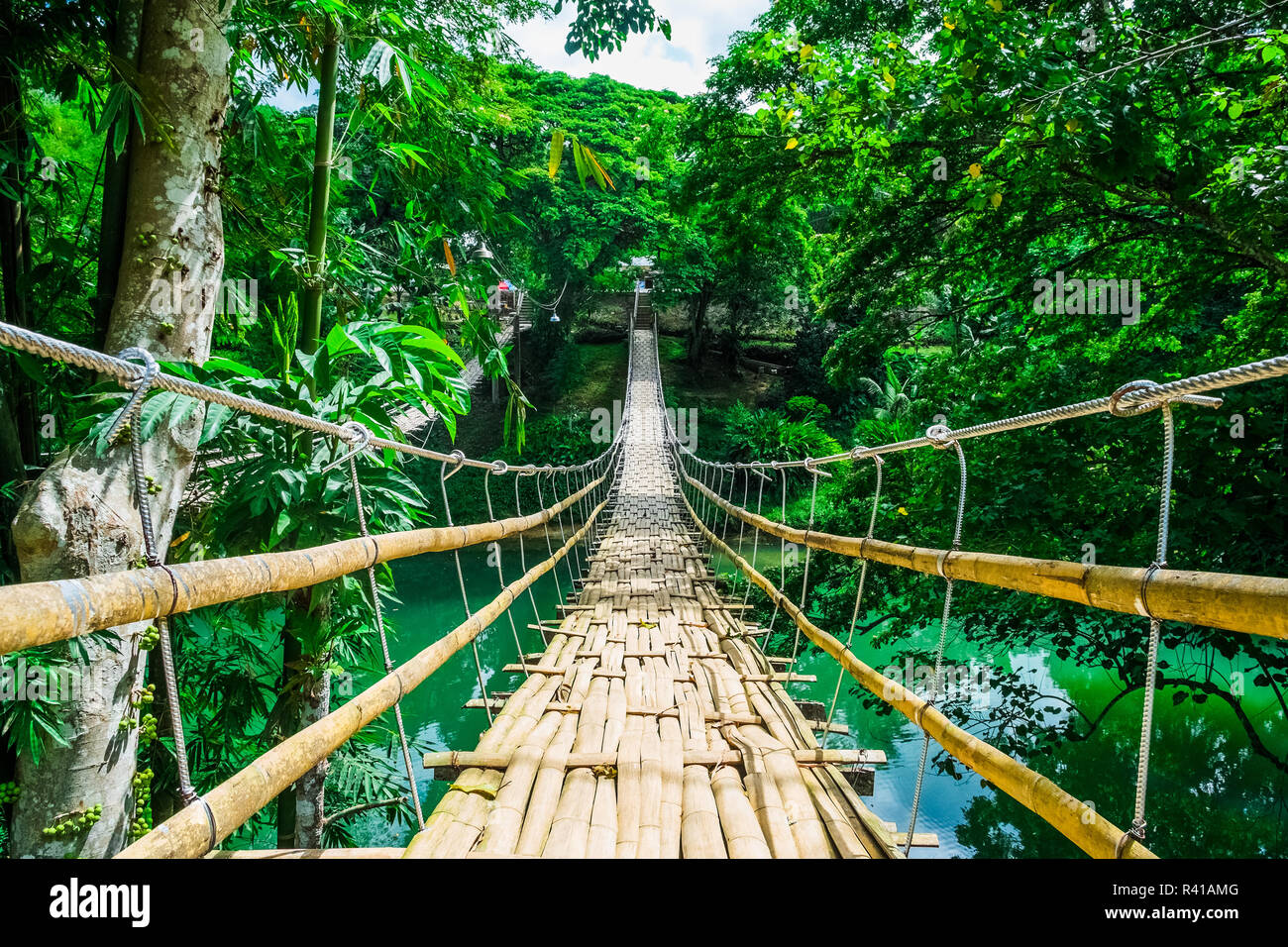 Bamboo pedestrian suspension bridge over river Stock Photo - Alamy