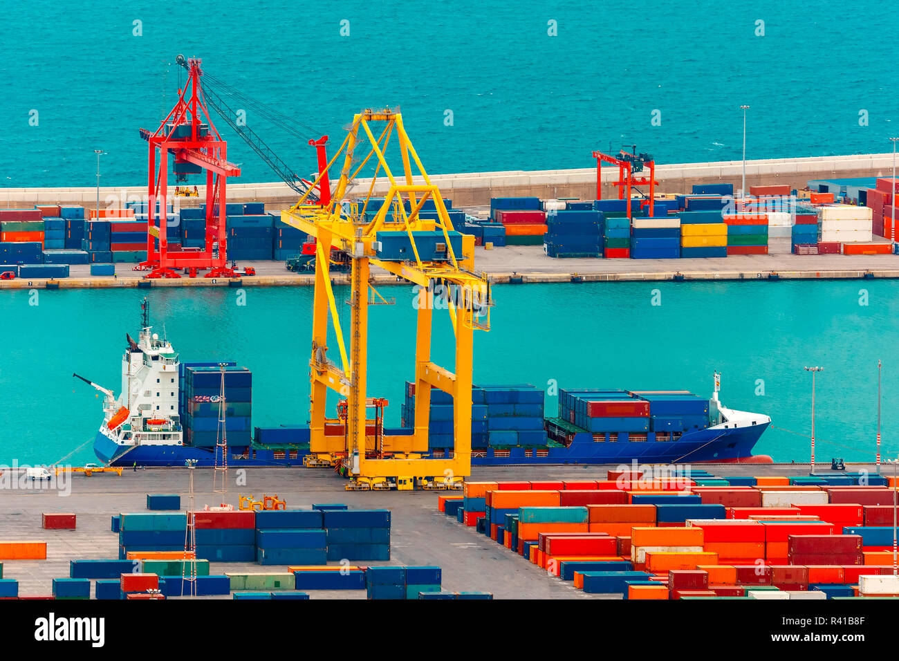 Loading containers on a sea cargo ship, Barcelona Stock Photo - Alamy