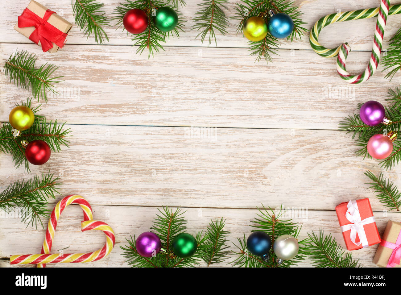 Christmas frame made of fir branches decorated with balls, candy canes ...