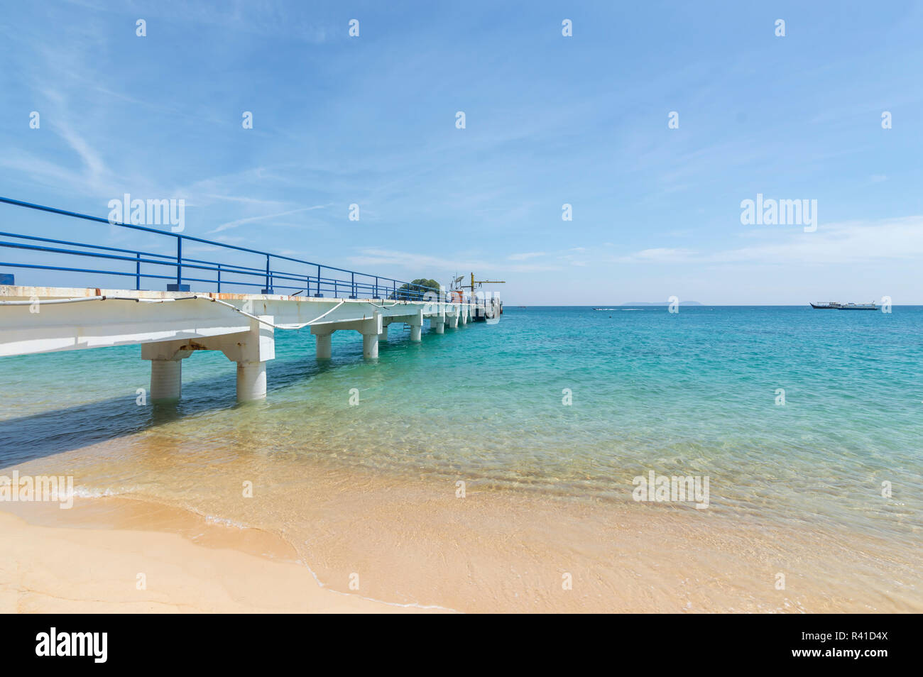 Jetty with clear water and blue skies Stock Photo - Alamy