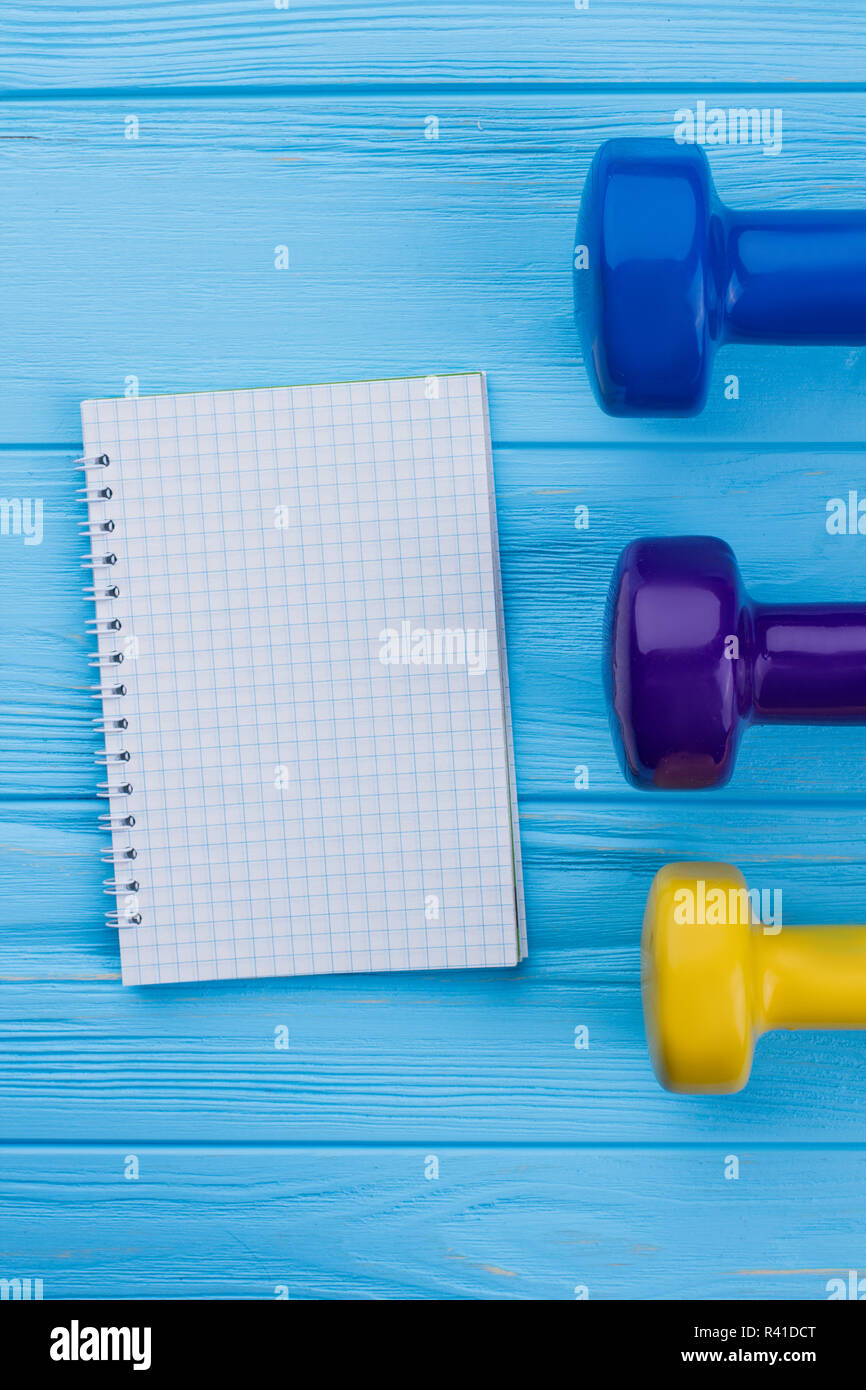 Dumbbells and blank paper notebook. Fitness equipmet and empty paper ...