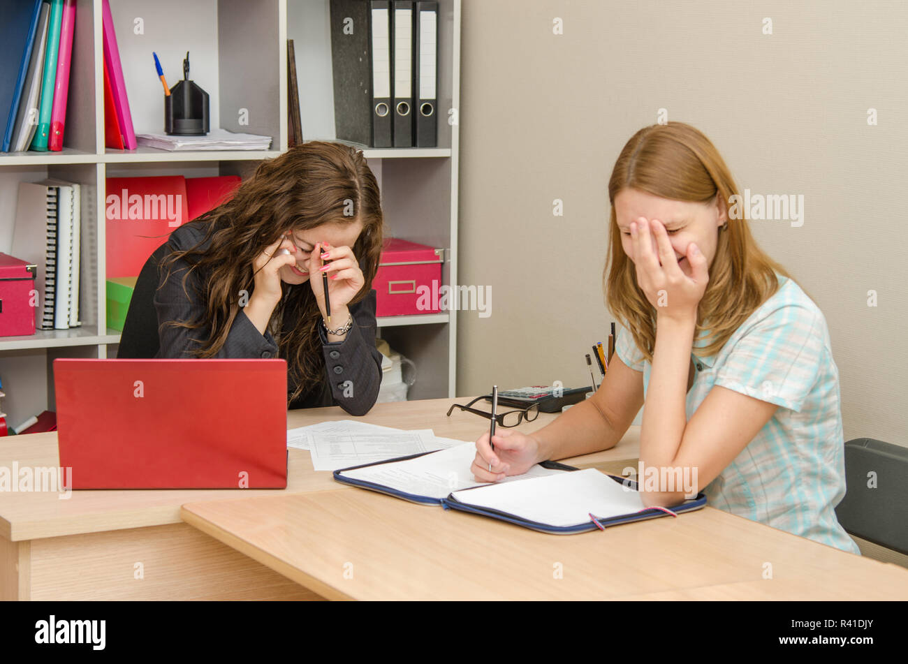Two employees of laughing at work in the office Stock Photo - Alamy