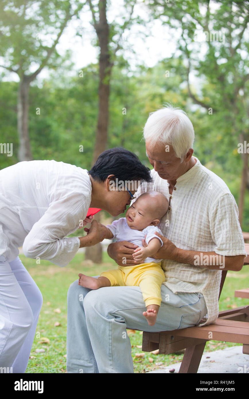 chinese grandfather and grandmother playing with baby grandson at ...