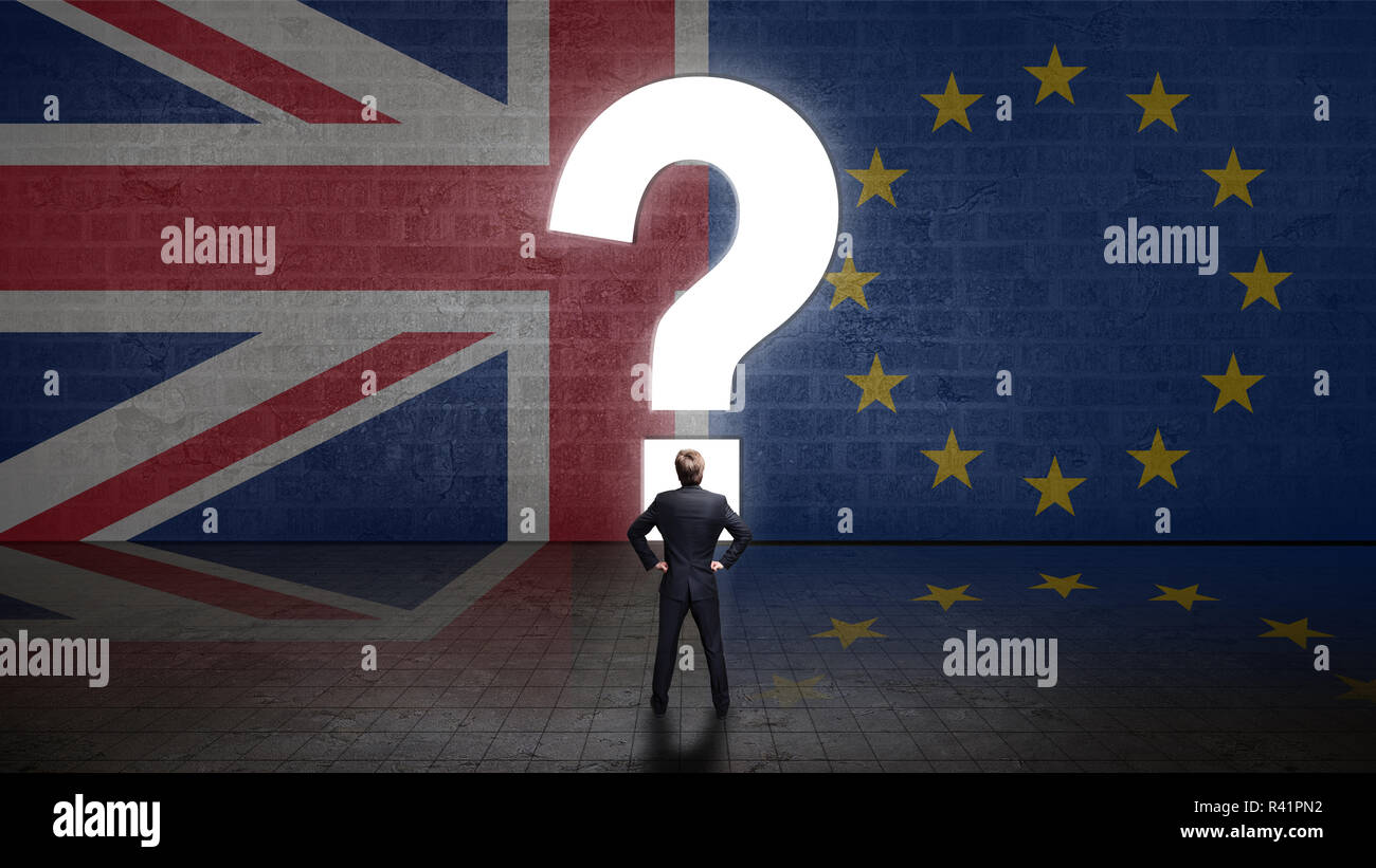 businessman standing in front of a wall with the union jack and the eu ...