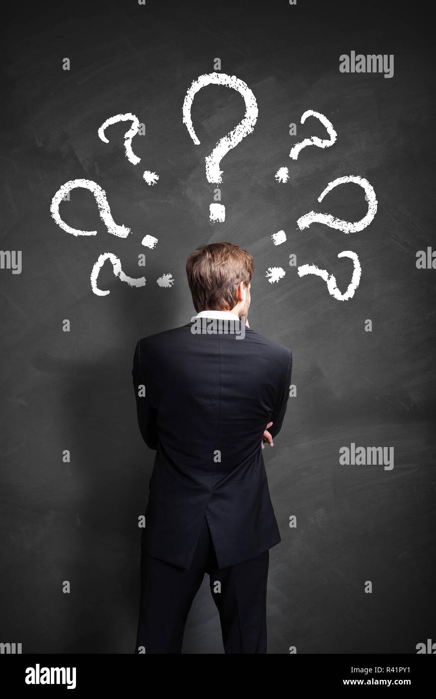 businessman having many questions symbolized as questionmarks on a ...