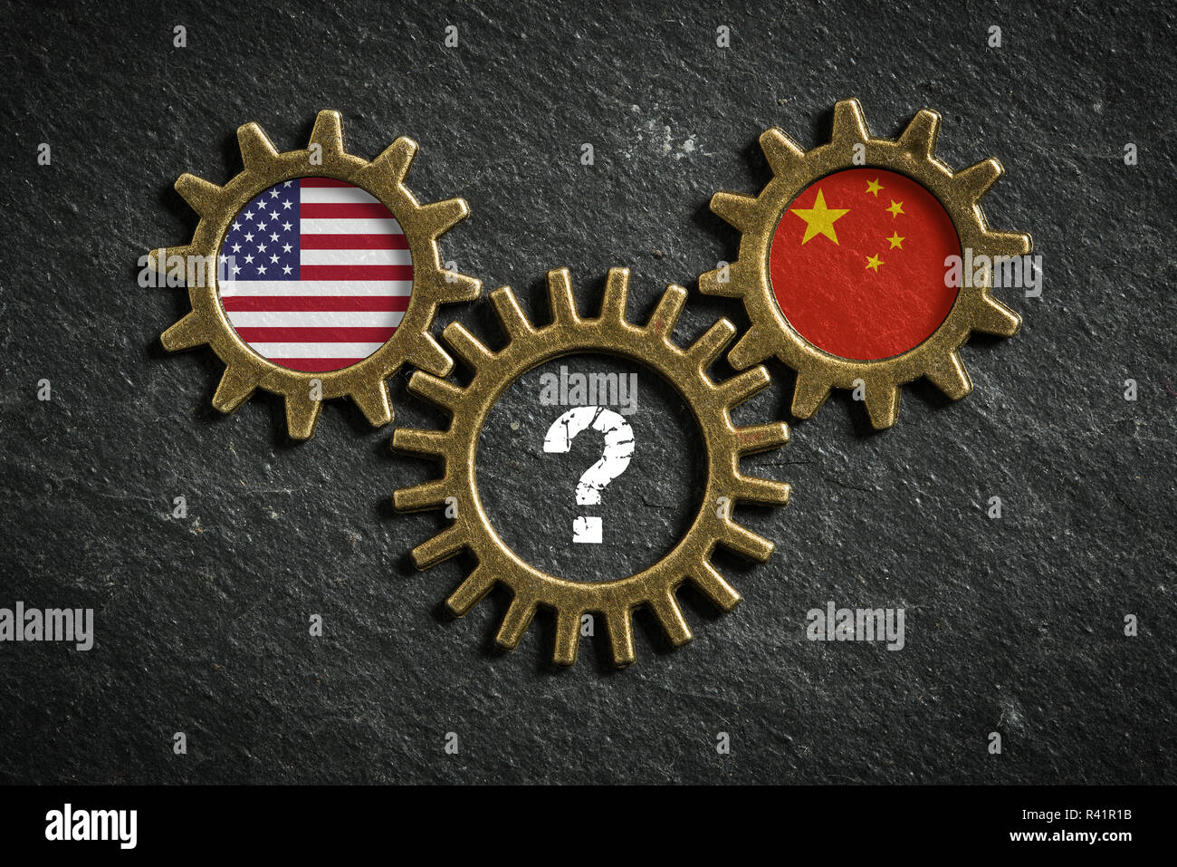 three cogwheels on slate background with the flags of USA and the China ...