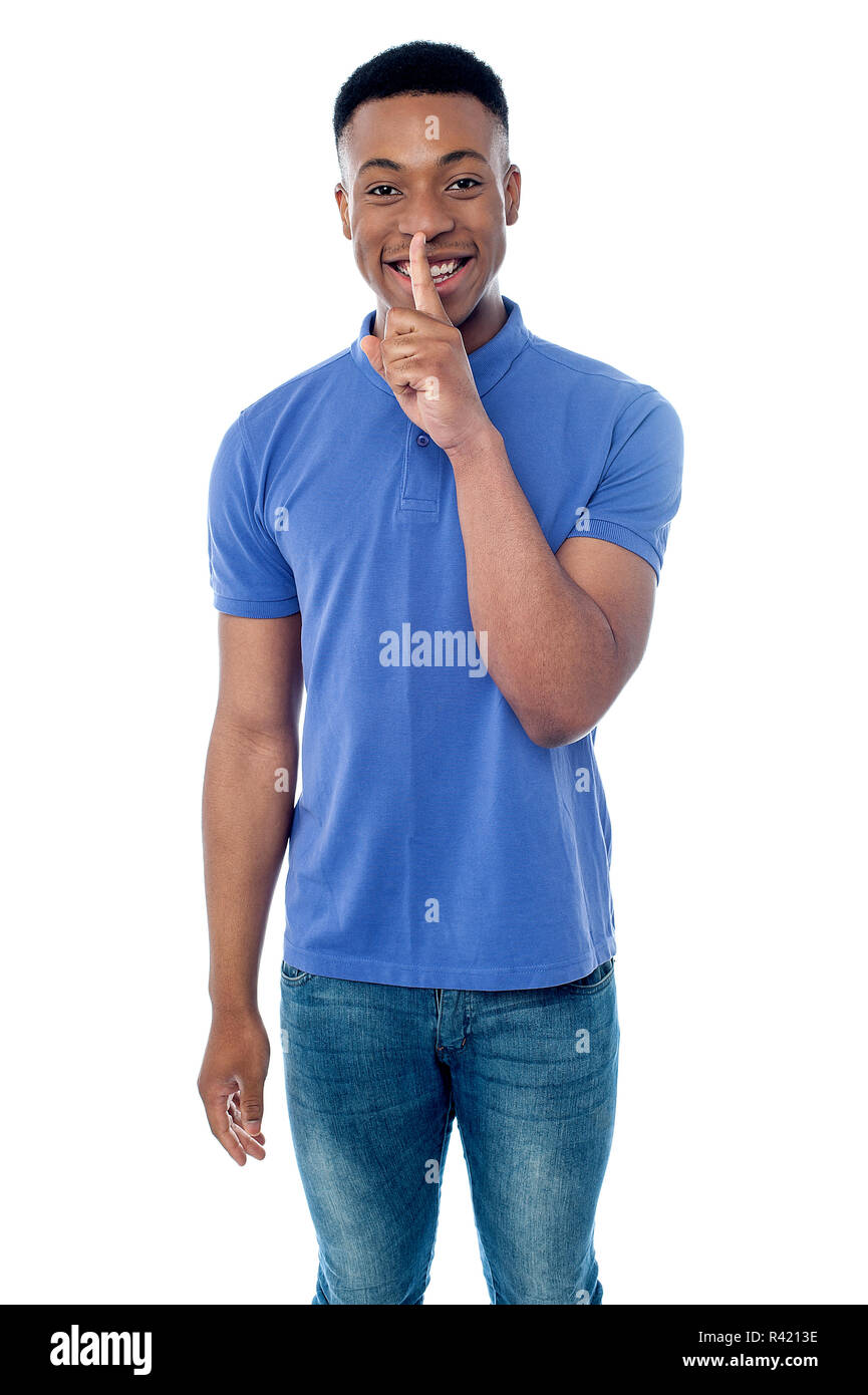 Boy showing silent sign, finger on lips Stock Photo - Alamy