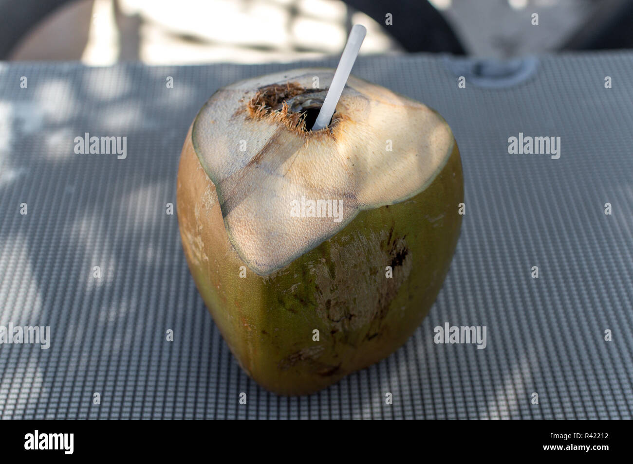 Fresh coconut with the straw inside of it Stock Photo - Alamy